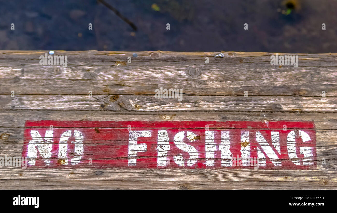 Wooden platform with painted No Fishing sign Stock Photo - Alamy