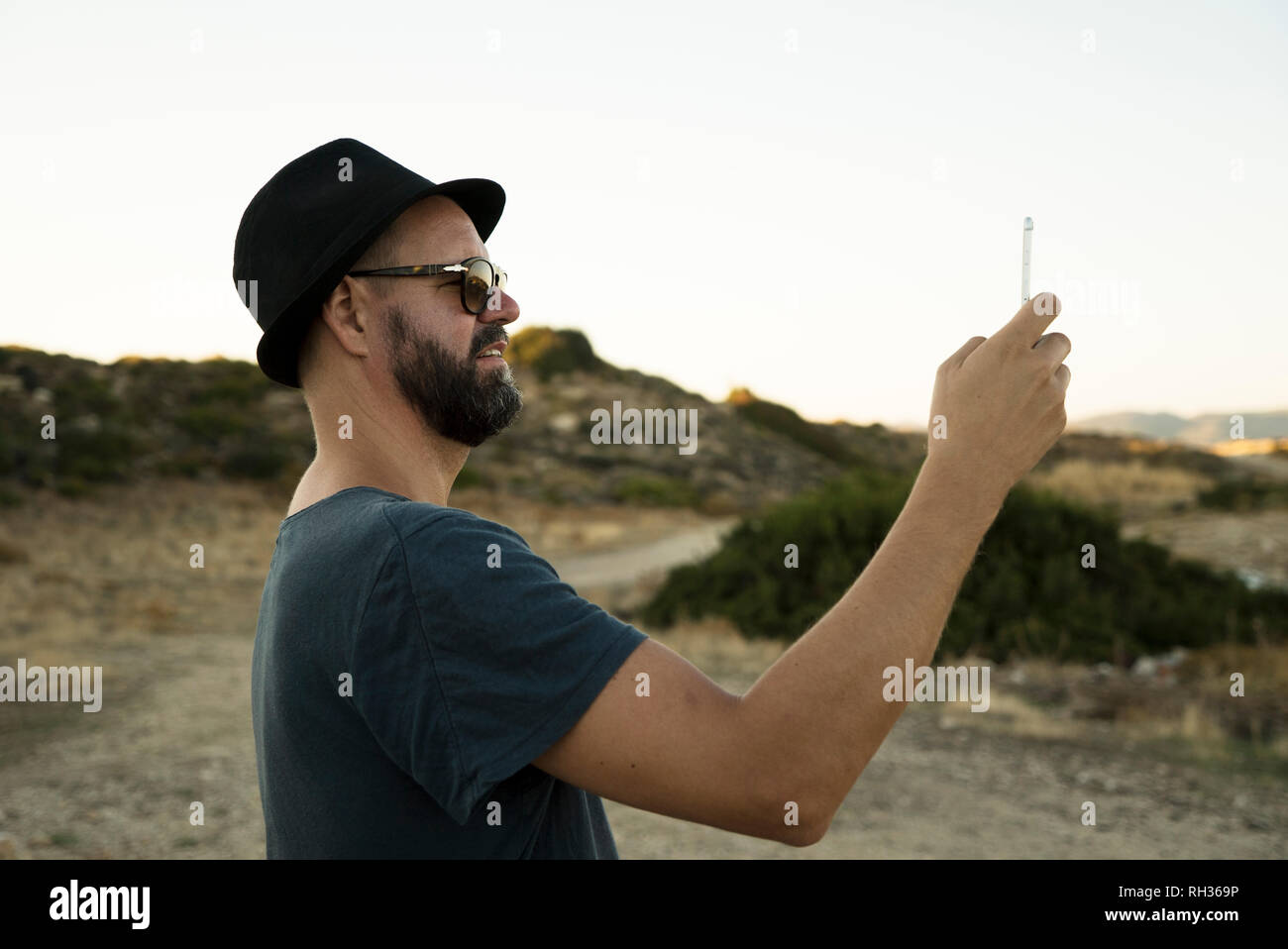 Man taking photo with cell phone Stock Photo - Alamy