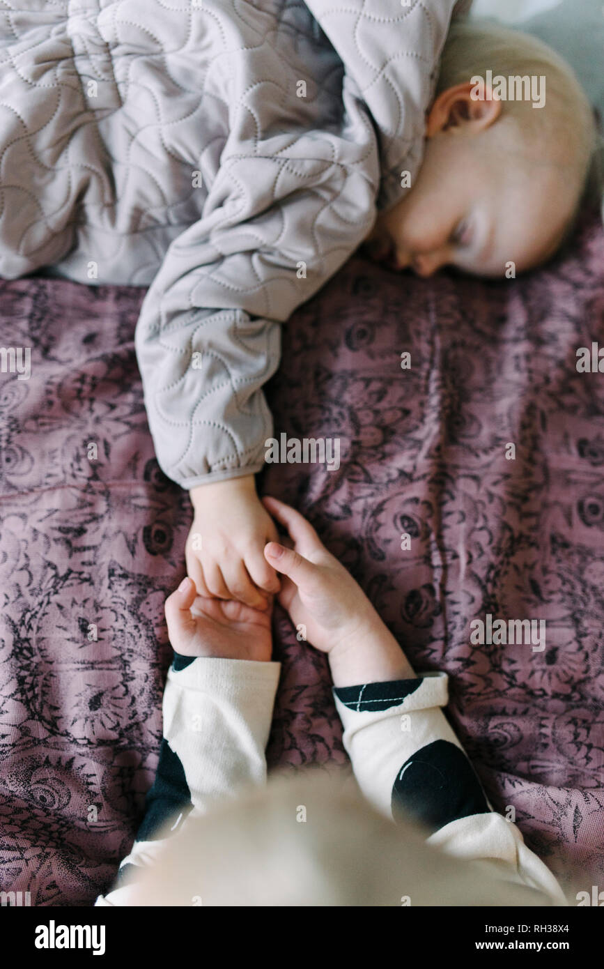 Girl holding brothers hand Stock Photo - Alamy