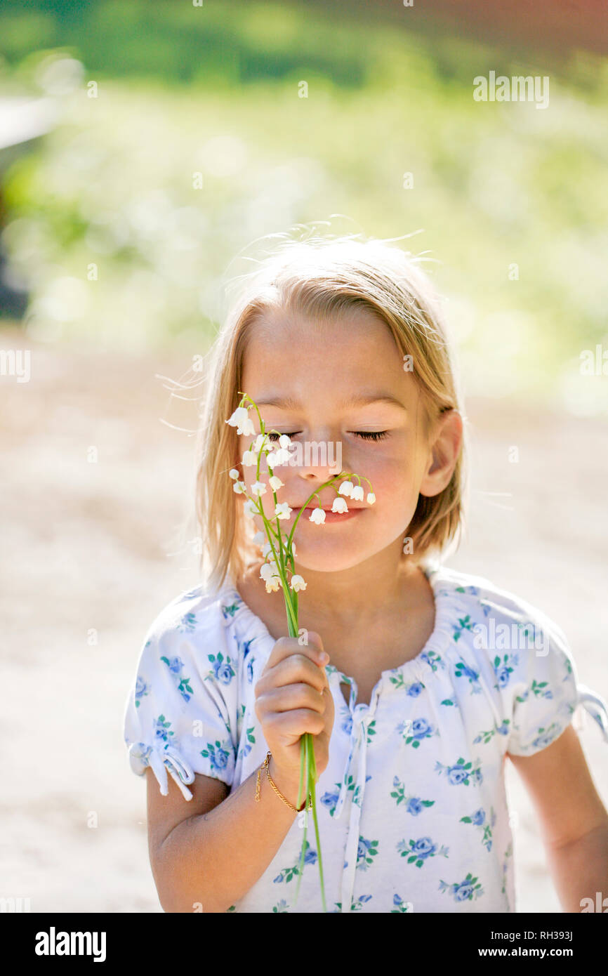 Girl smelling lily of the valley Stock Photo - Alamy