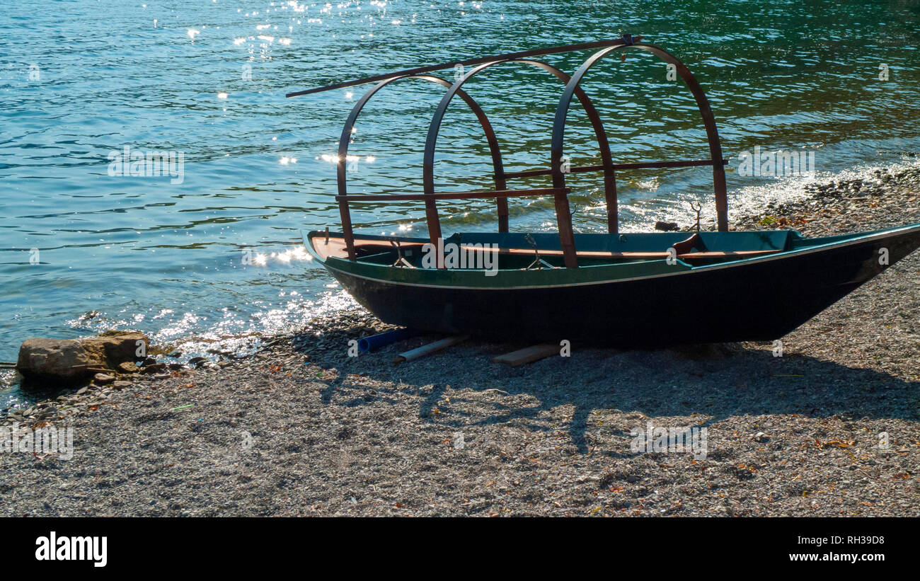 Ein altes Boot, Ausflugsschiff liegt am Ufer bei Lenno am comer See ...