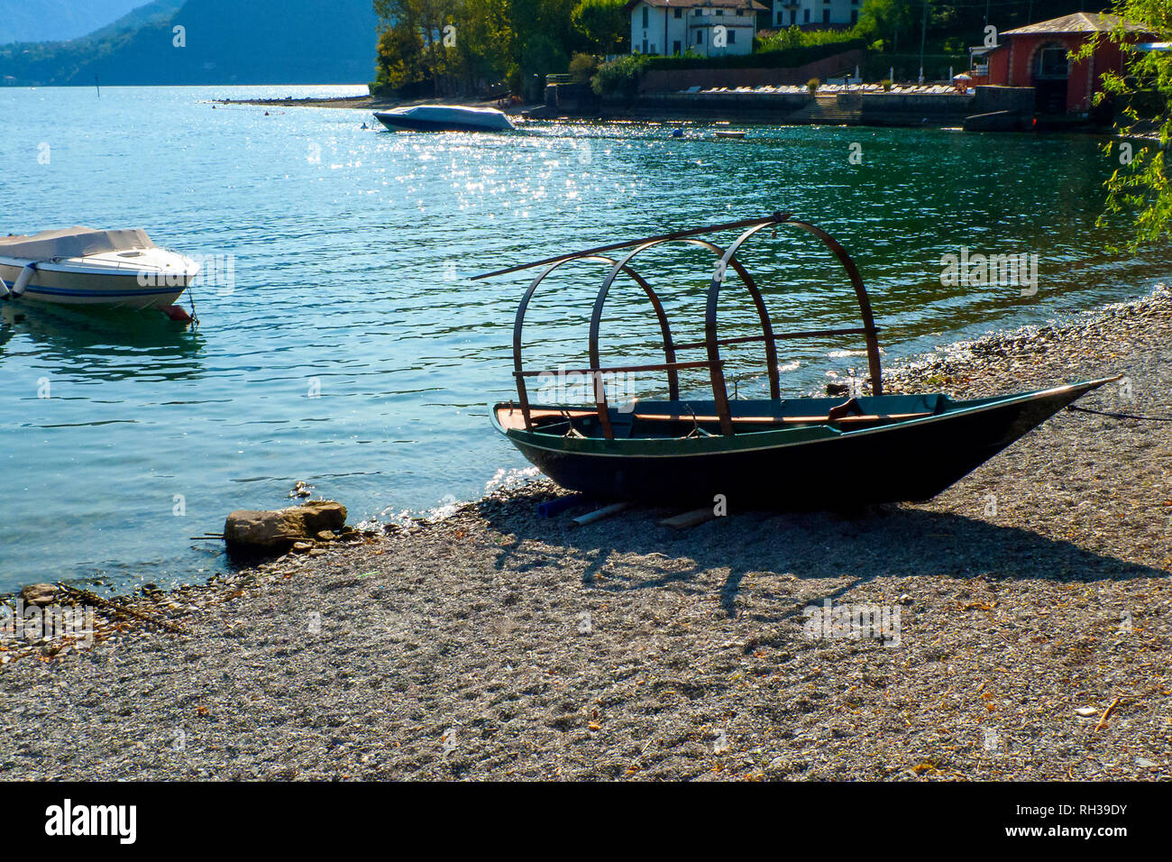 Ein altes Boot, Ausflugsschiff liegt am Ufer bei Lenno am comer See ...