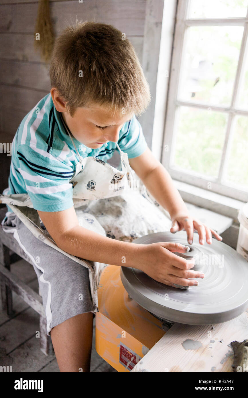 Boy forming pottery on wheel Stock Photo - Alamy