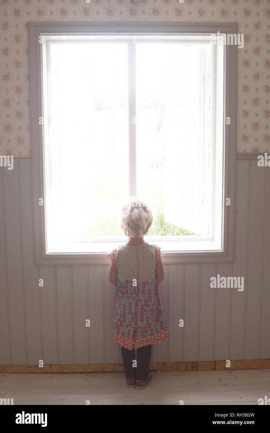 Girl looking through window Stock Photo - Alamy