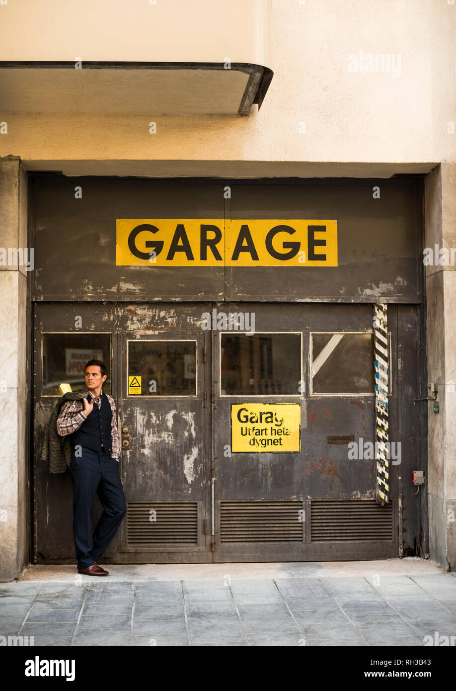 Elegant man in front of garage Stock Photo - Alamy