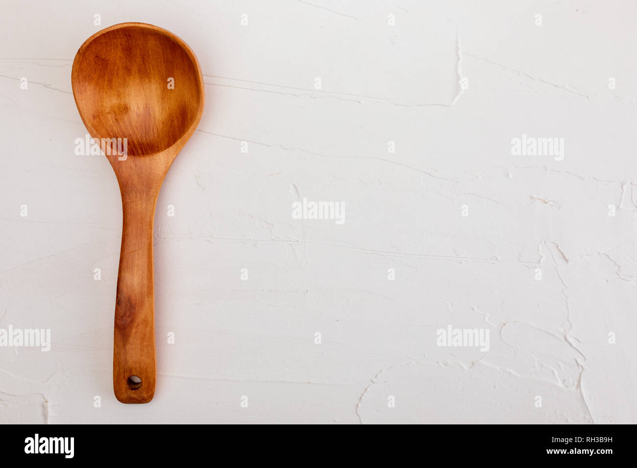 Wooden spoon on white background with texture. Space to insert your ...