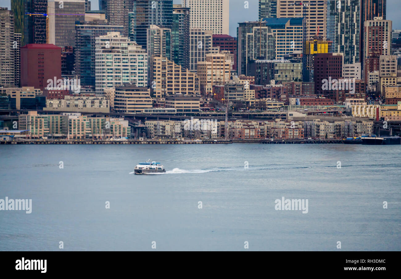 A boat cruises across Elliott Bay in front of the Seattle skyline Stock ...