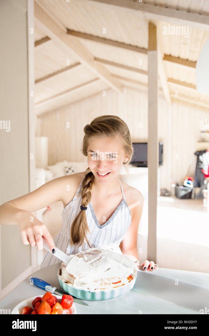 Smiling teenage girl making cake Stock Photo - Alamy