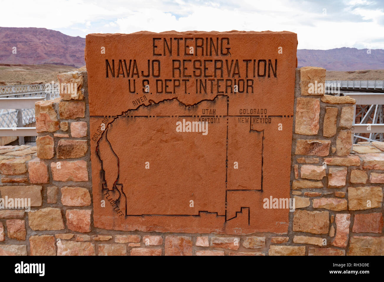 Sign "Entering Navajo Reservation" with the Navajo Bridge behind ...