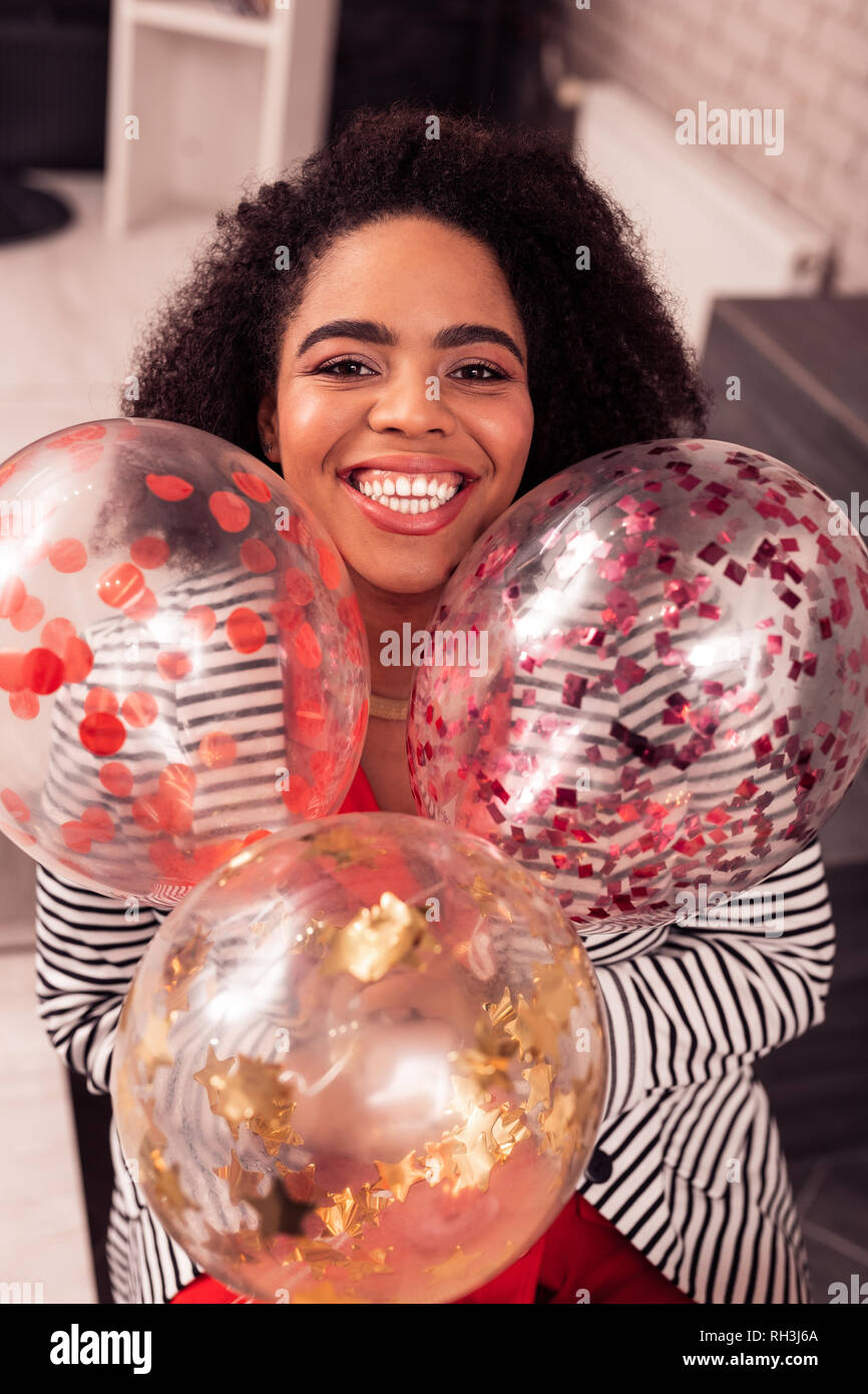 Happy positive woman holding beautiful colorful balloons Stock Photo ...