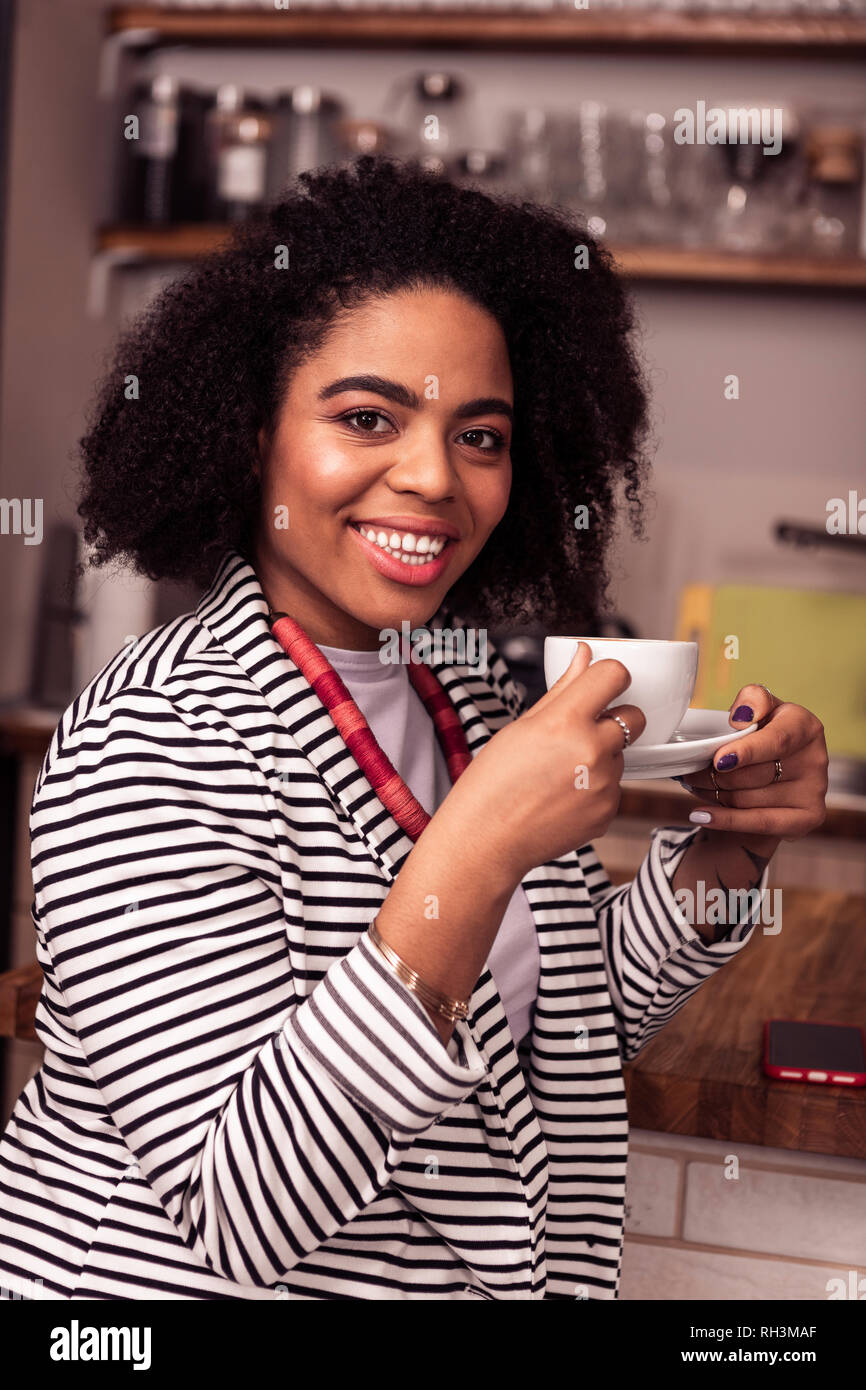Happy delighted woman enjoying her tasty cappuccino Stock Photo - Alamy
