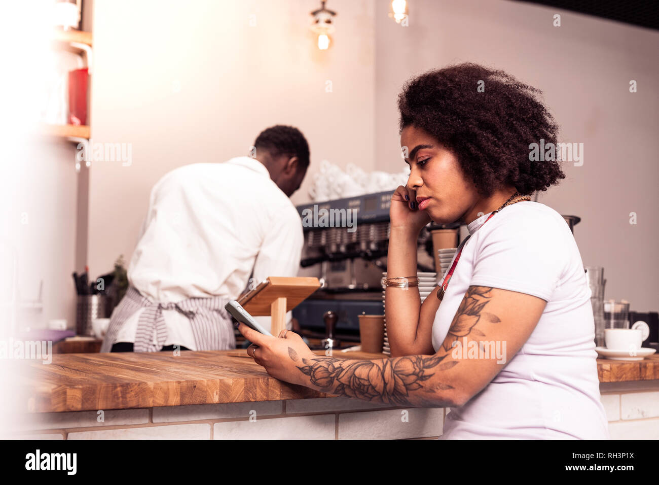 Nice pleasant woman waiting for her coffee Stock Photo - Alamy