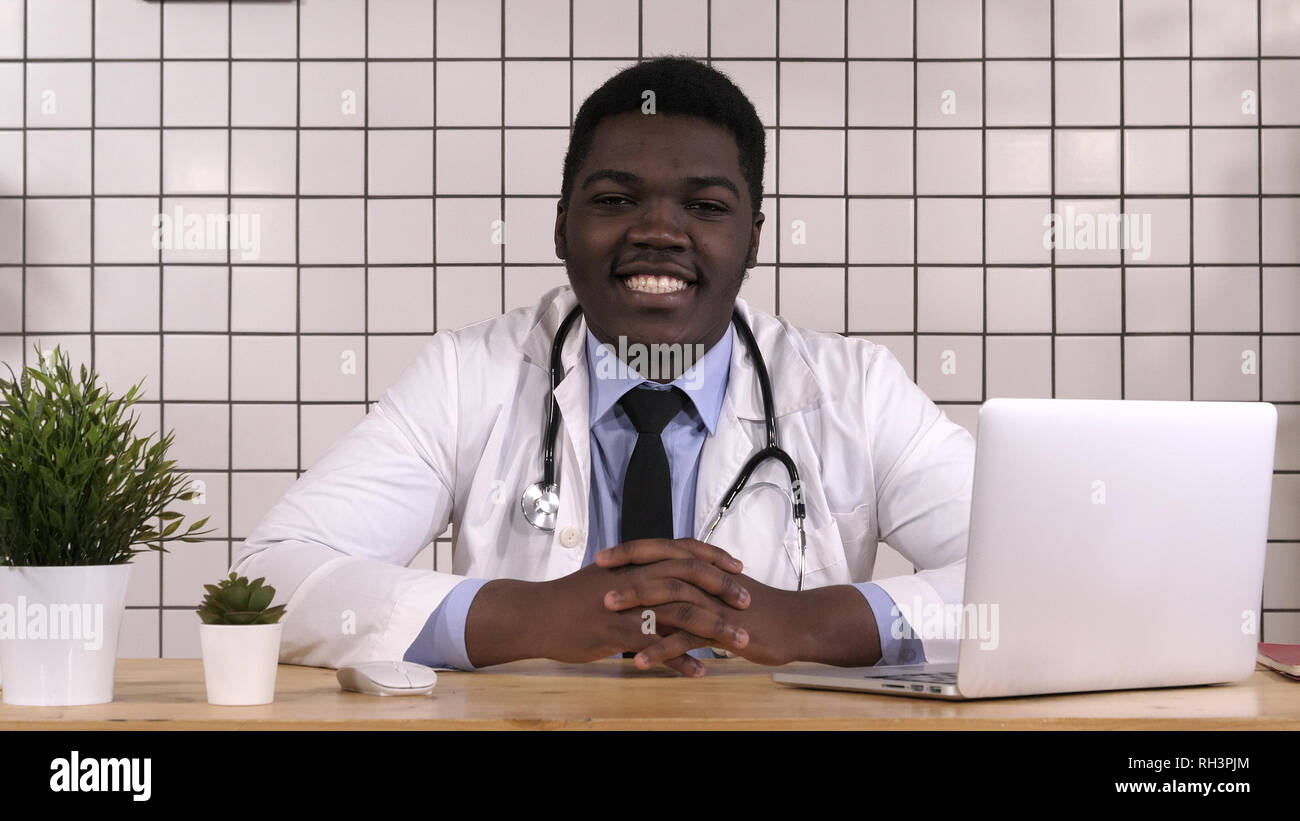 Young doctor at his working place smiling Stock Photo - Alamy