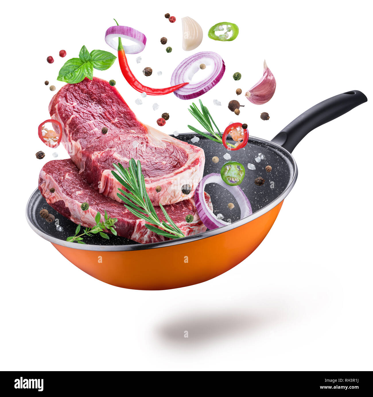 Flying meat steaks and spices over a frying pan. File contains clipping ...