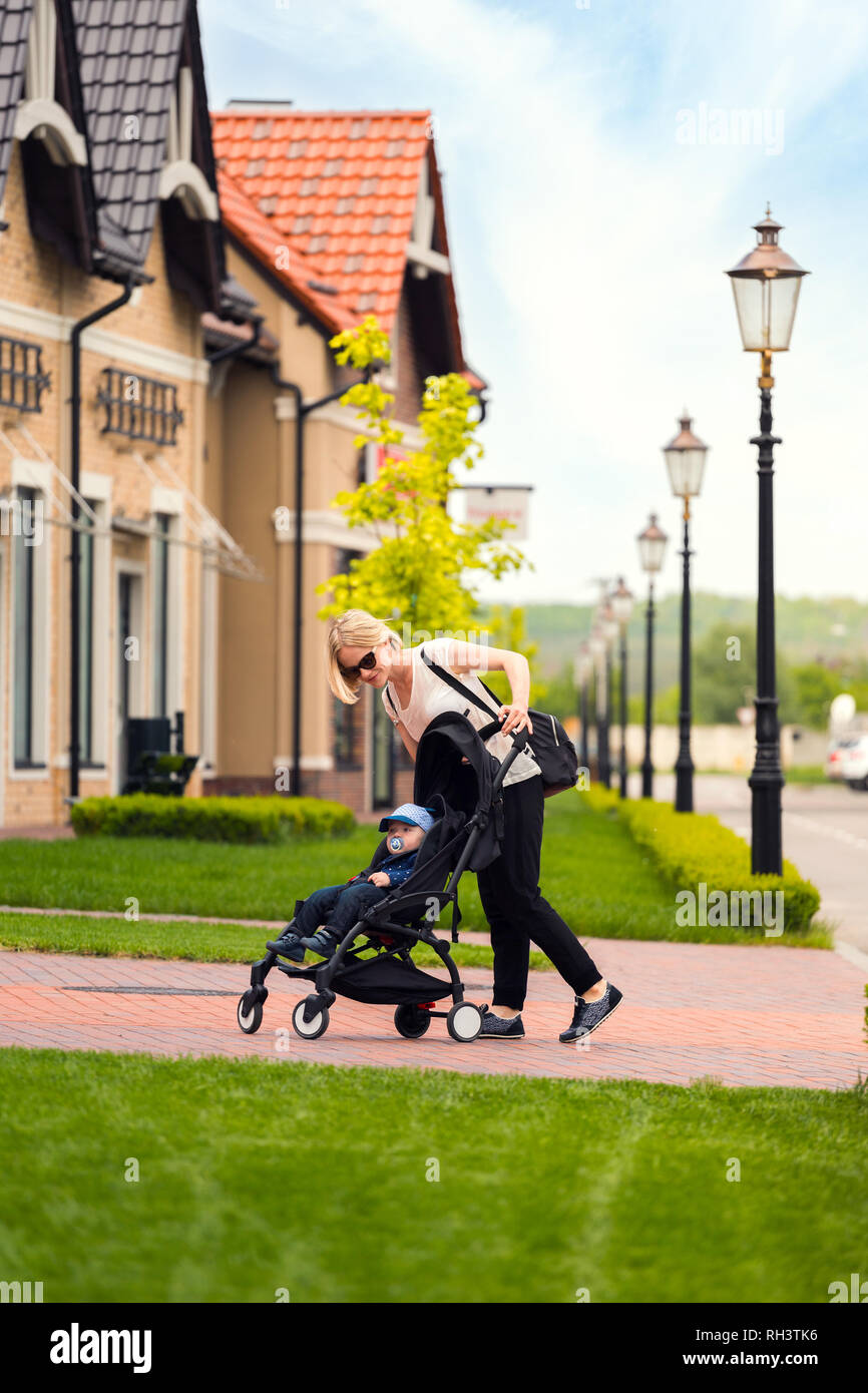 Mother carries her child in a stroller for a walk Stock Photo - Alamy