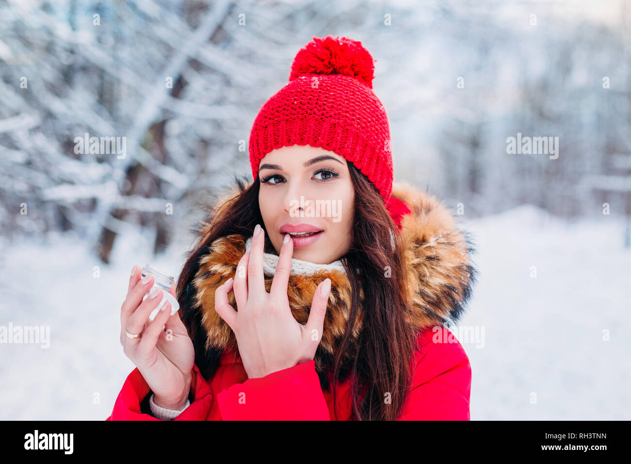 Girl protecting lips with lip balm in winter Stock Photo - Alamy