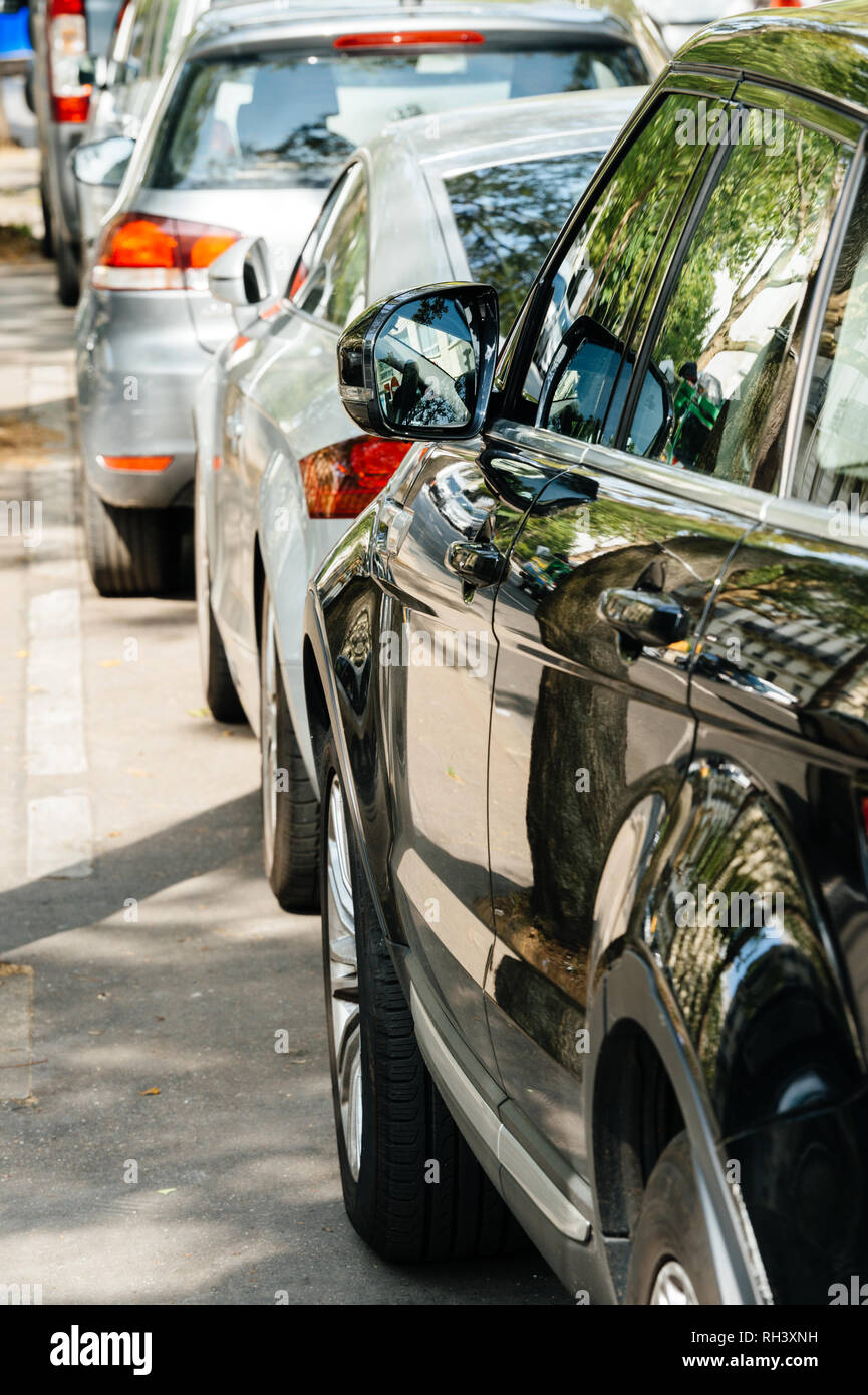 Modern cars in a row parked on Paris street during the day Stock Photo ...