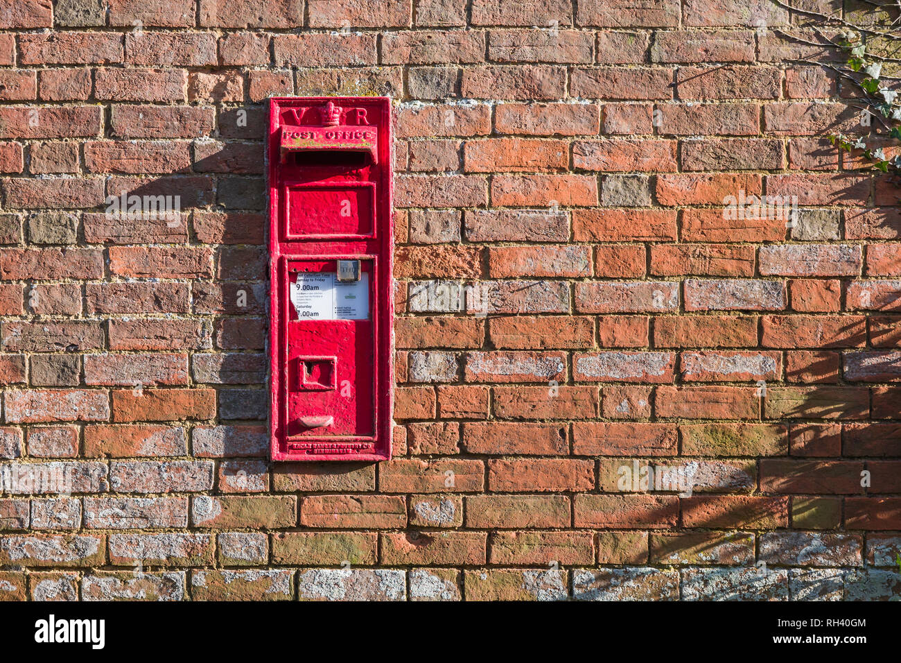 Old Victorian post box built into old red brick wall in farm barn ...