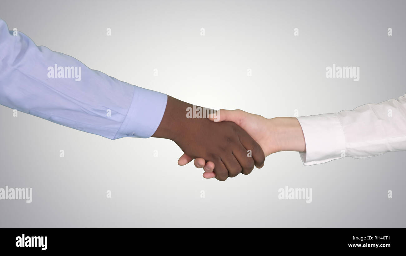 Handshake of Afro American and caucasian female hands on gradient ...