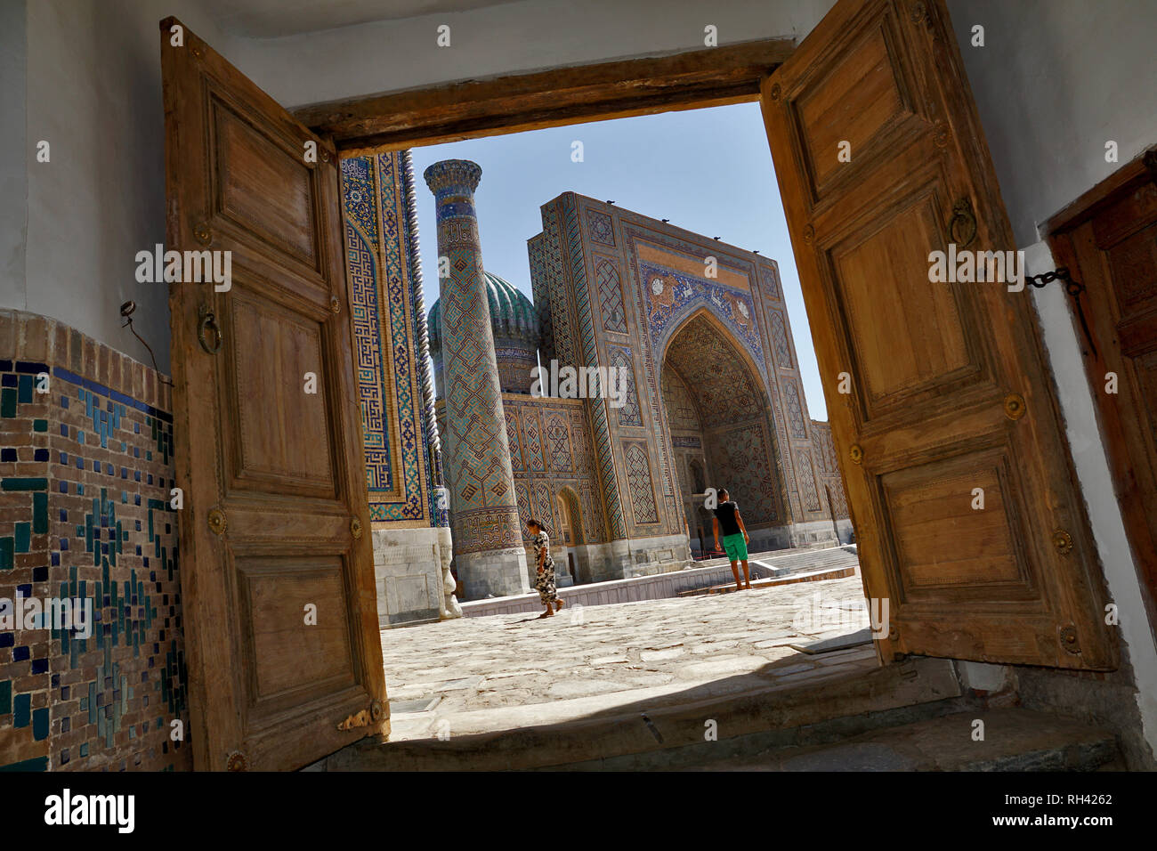 ancient wooden gate with view to Mosque and Madraasah Registan Square ...