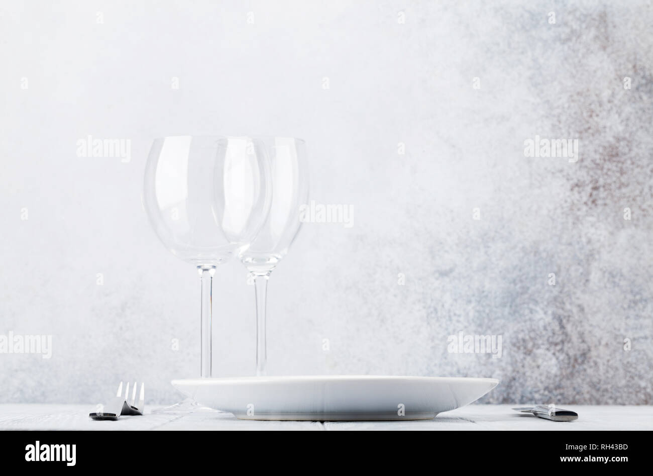 Dinner plate setting with cutlery and glasses. View with copy space ...