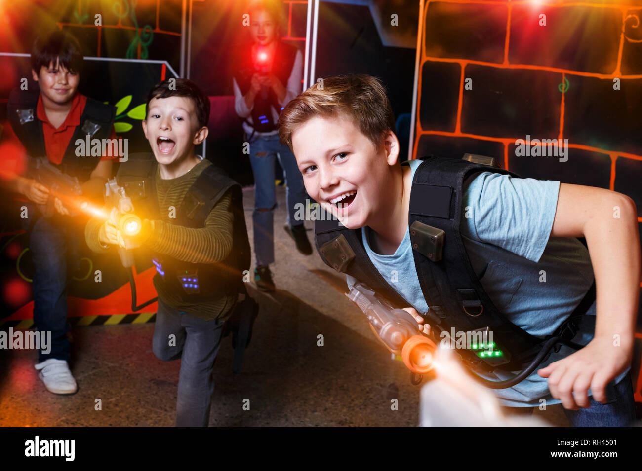 portrait of excited sportive young boy aiming laser gun at other ...