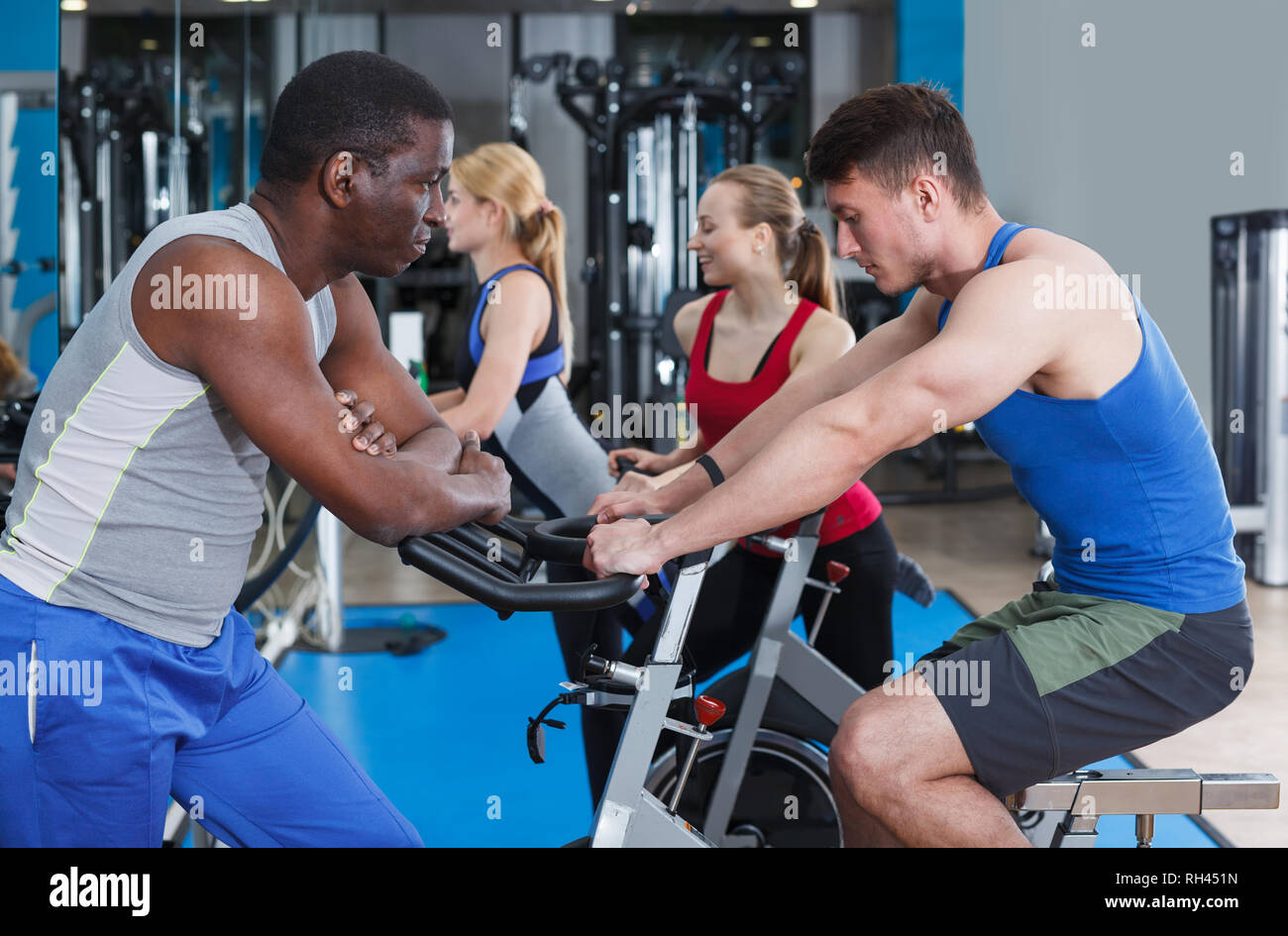 Positive sports guys talking while training in fitness gym Stock Photo ...