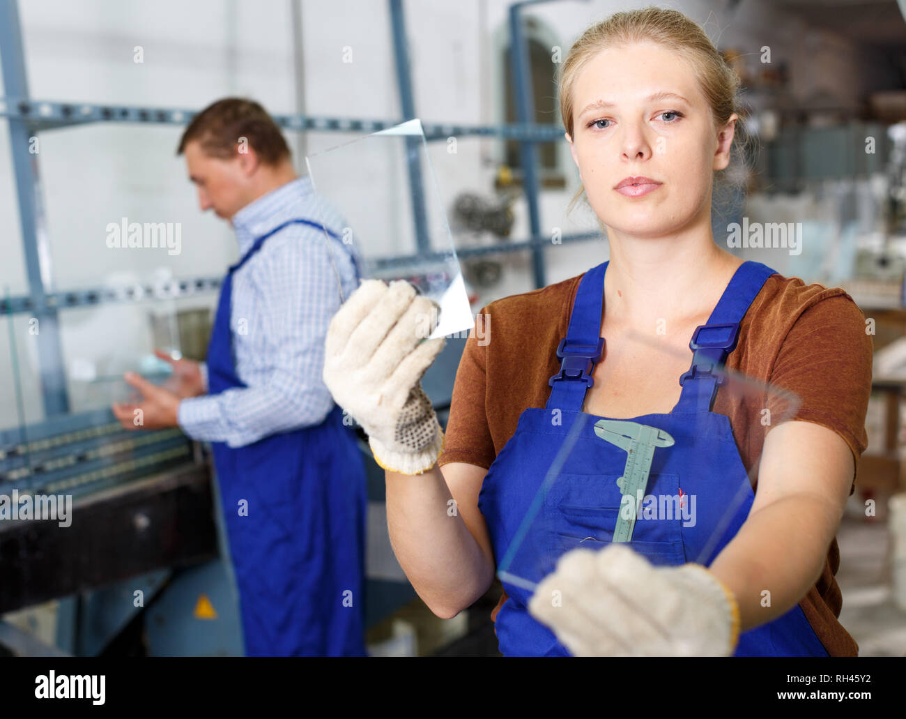 Portrait of qualified female glazier during daily work in glass factory ...