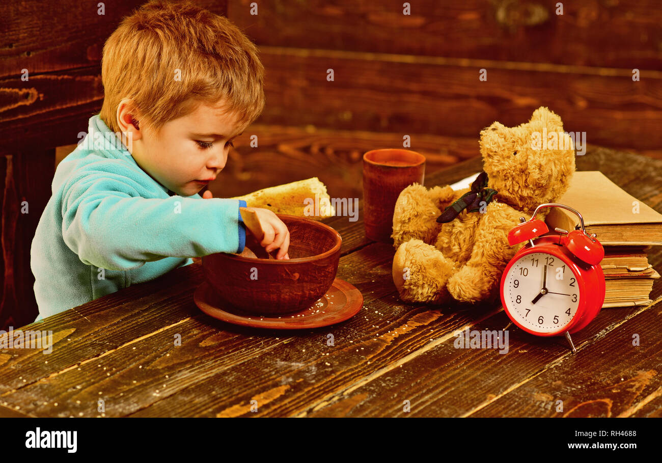Kid eat food at wooden table. Kid enjoy meal with toy friend. Kid menu ...