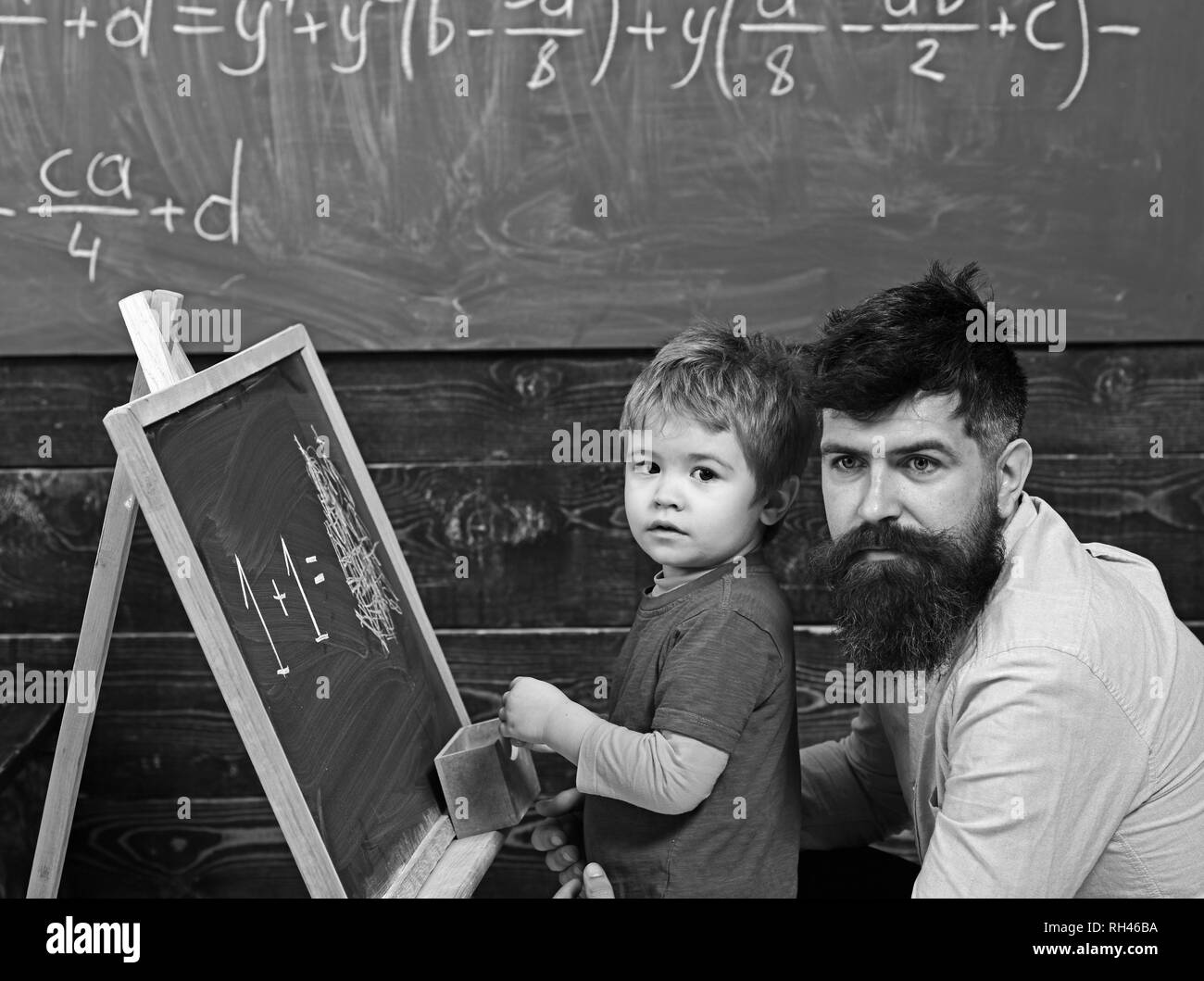 Preschool kid and his teacher in the classroom. Father helping his ...