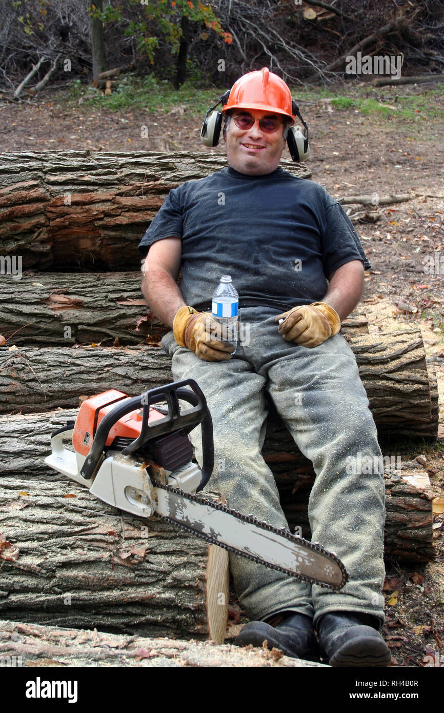 Middle aged guy cutting wood on farm Stock Photo - Alamy