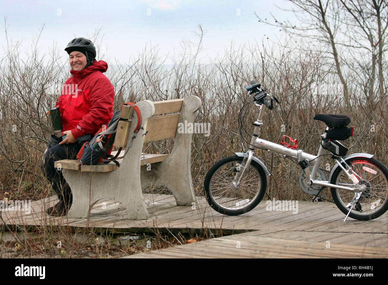 Happy guy with fold up bike resting on park bench Stock Photo - Alamy