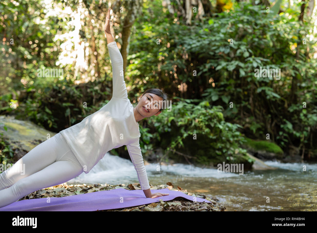 Beautiful girls are playing yoga at the park. Among the natural ...
