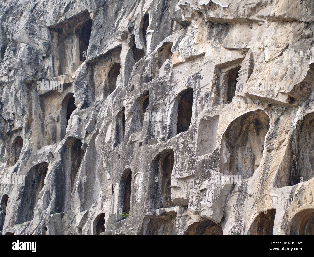Luoyang Longmen grottoes. Broken Buddha and the stone caves and ...