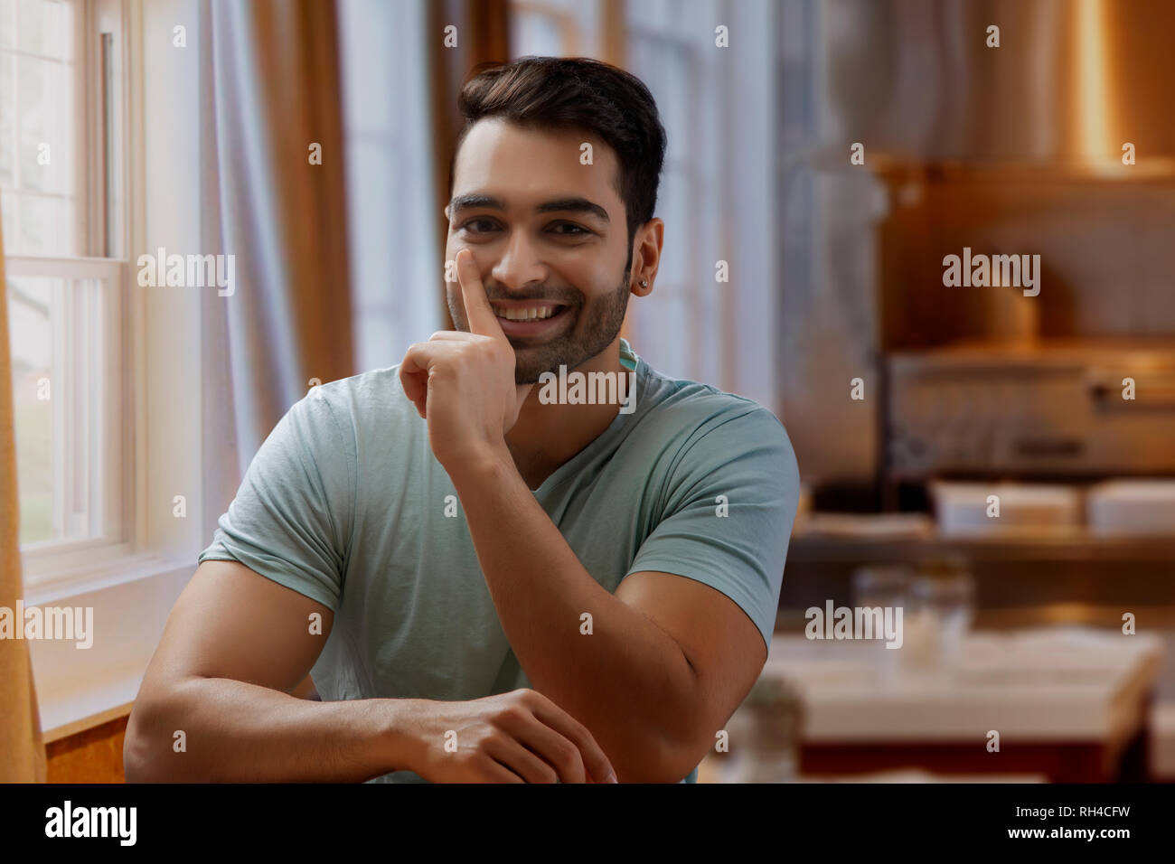 portrait of a young man sitting in a coffee shop hand rests on the ...