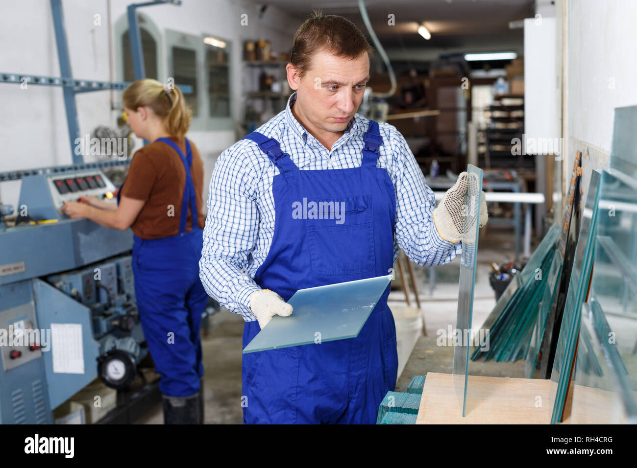 Experienced male glazier during daily work in glass factory Stock Photo ...