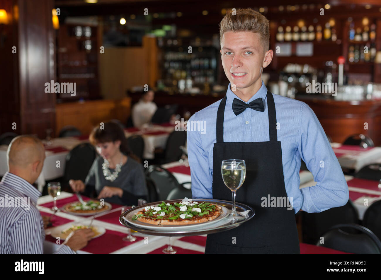 Handsome elegant waiter with serving tray welcoming to restaurant Stock ...