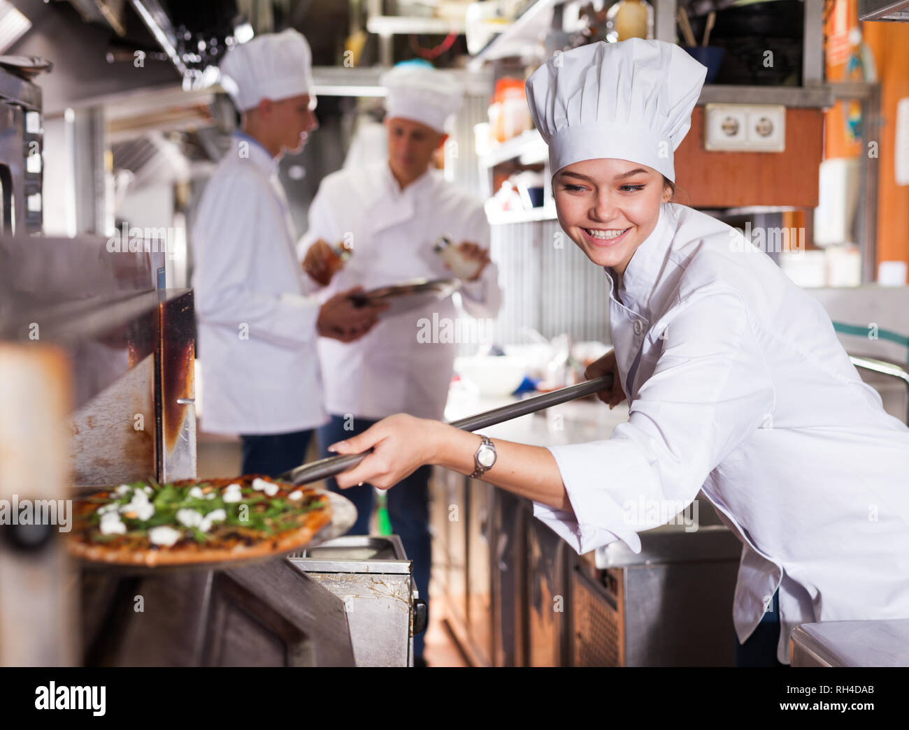 Portrait of confident young woman chef working in modern restaurant ...