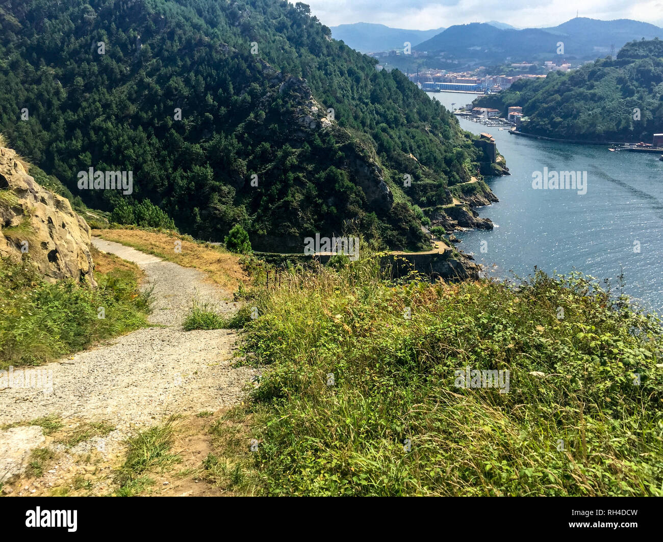 winding coastal road at the steep coast of an harbor entrance in Basque ...
