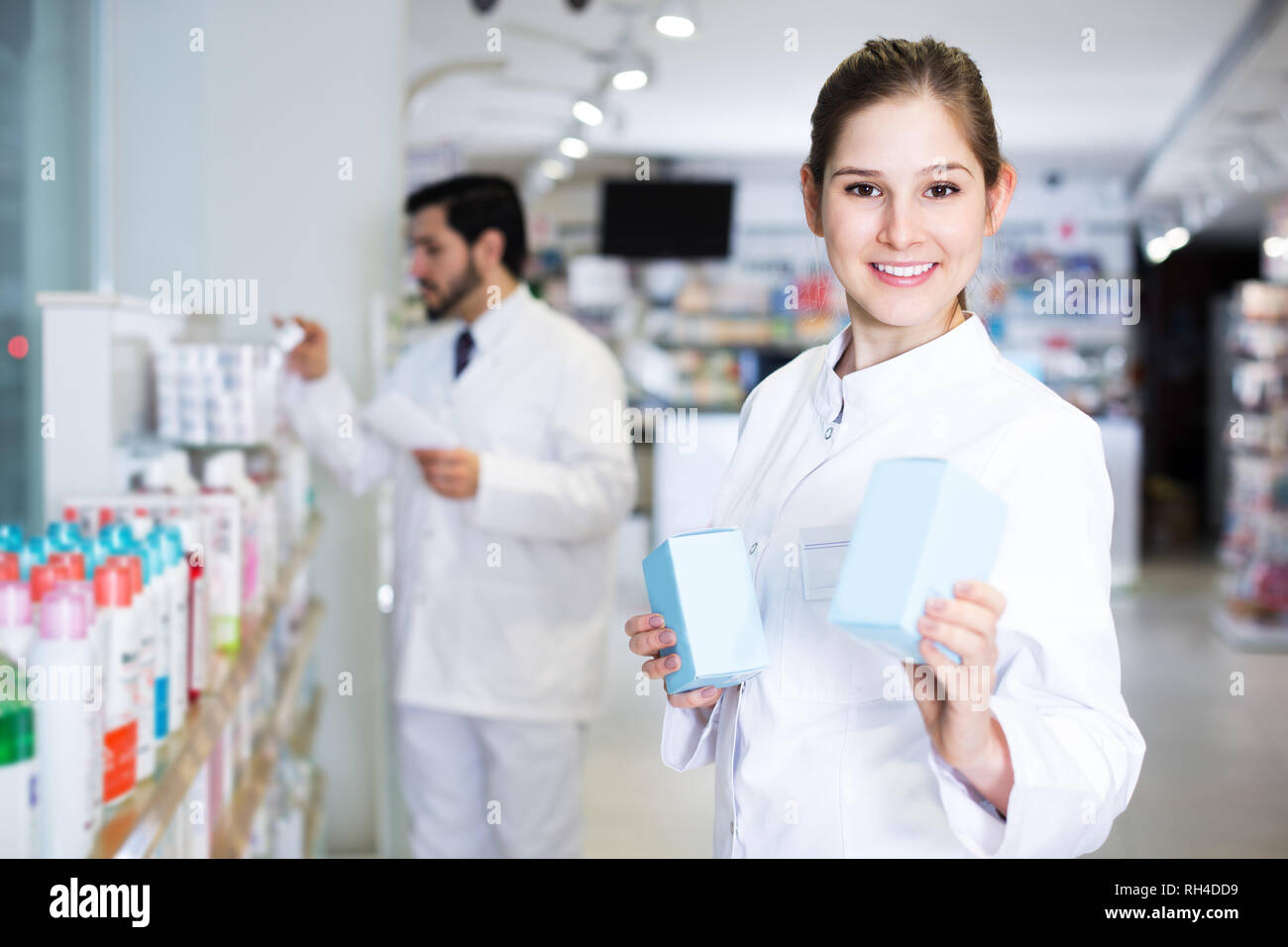Smiling female pharmacist is standing with medicines in drugstore Stock ...