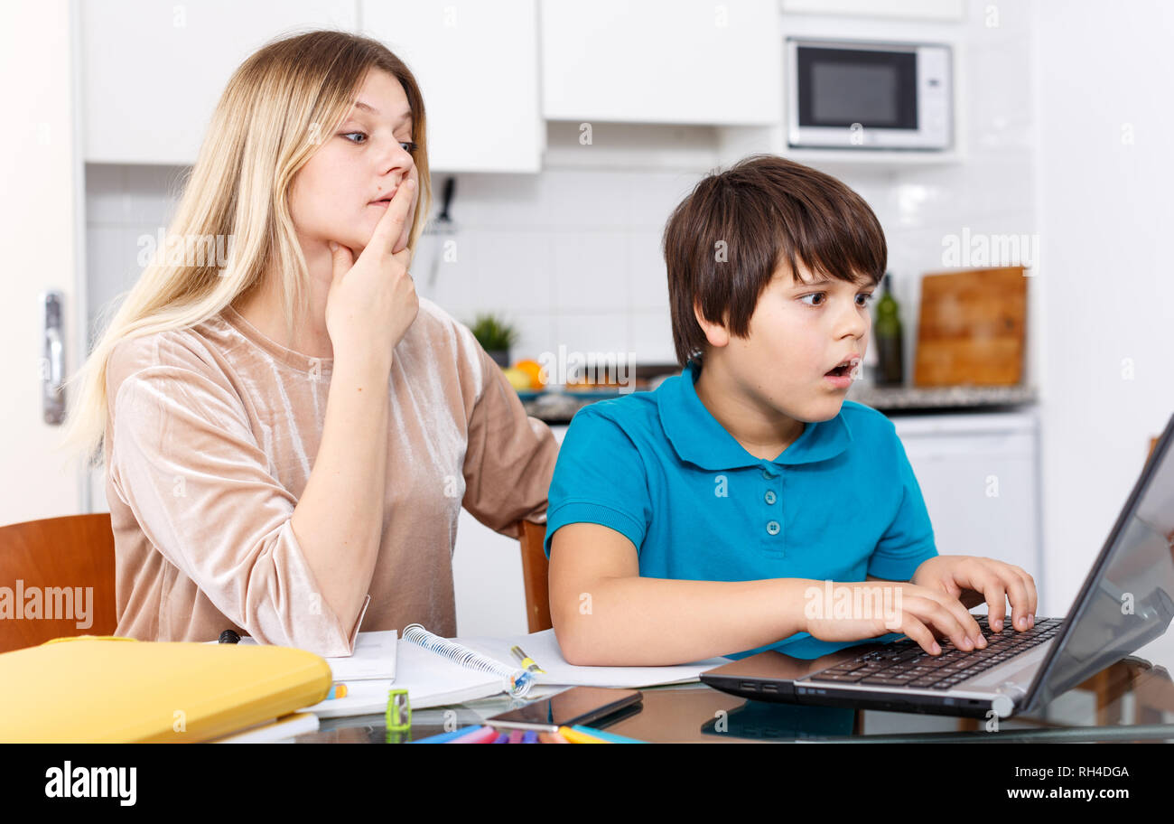 Portrait of emotional woman and boy doing homework with laptop at ...