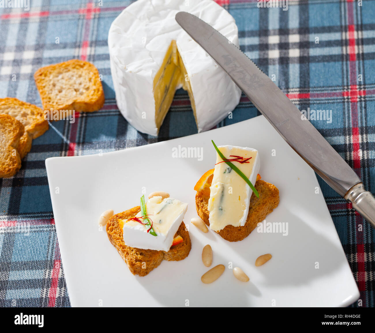 Small slices of toasted bread with soft blue cheese and orange ...