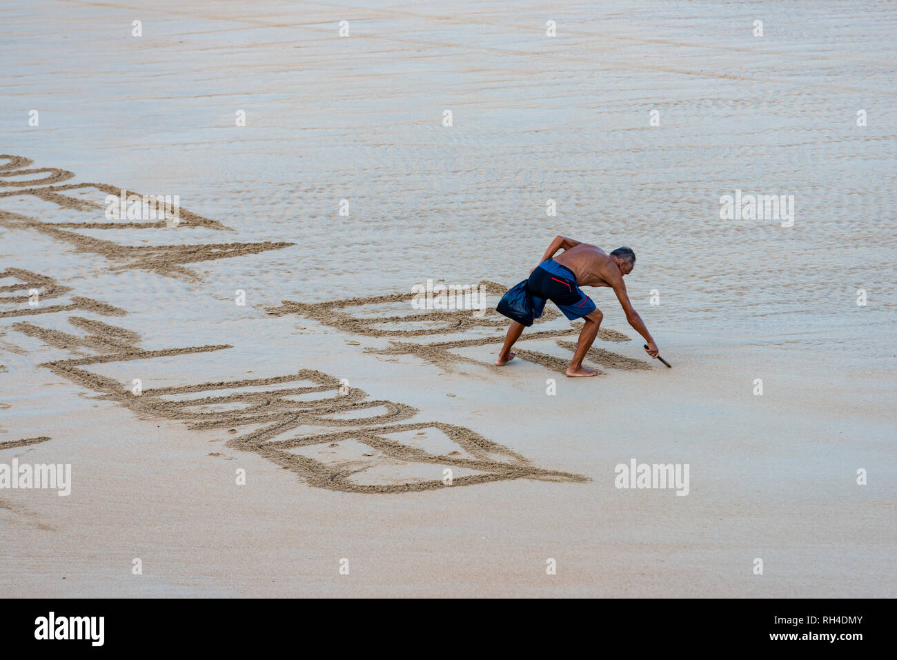 man writing a message in the sand of San Sebastian beach Stock Photo ...