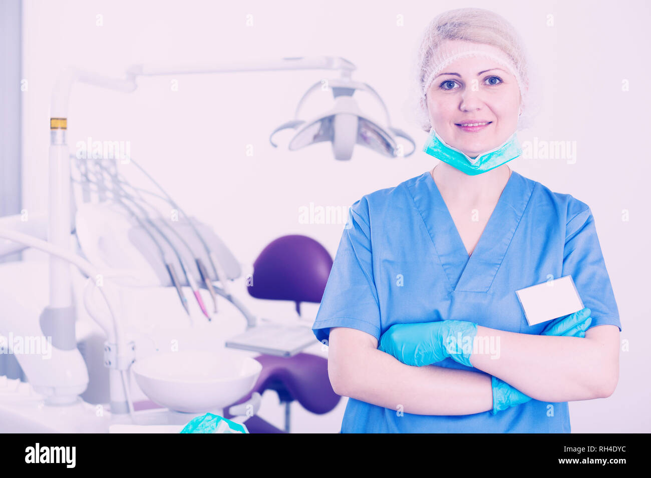 Portrait of professional woman dentist posing with arms crossed at ...