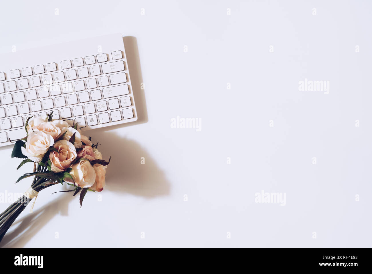 Top view of rose flower on the wireless keyboard on white background ...