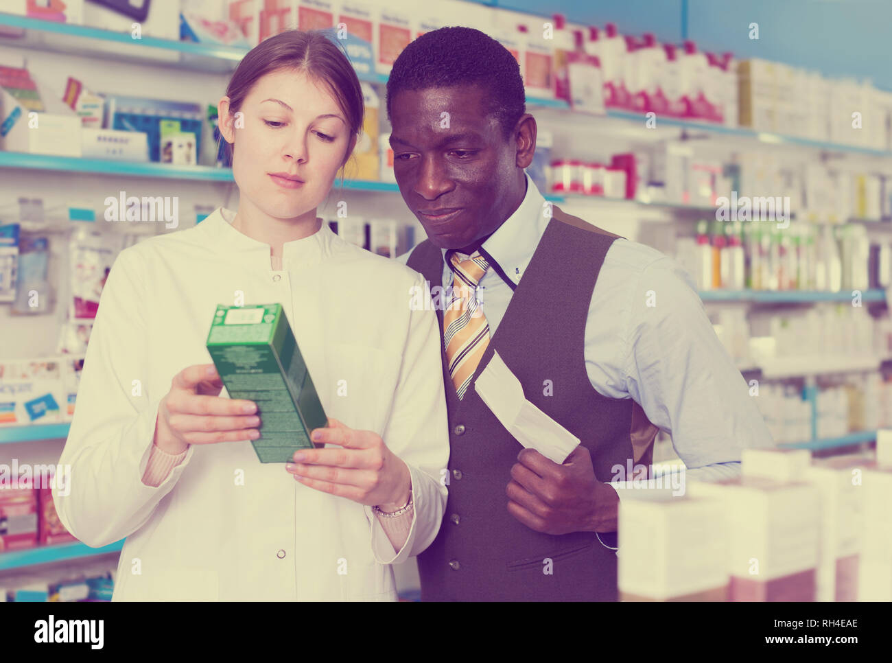 Experienced woman pharmacist helping male client picking up ...