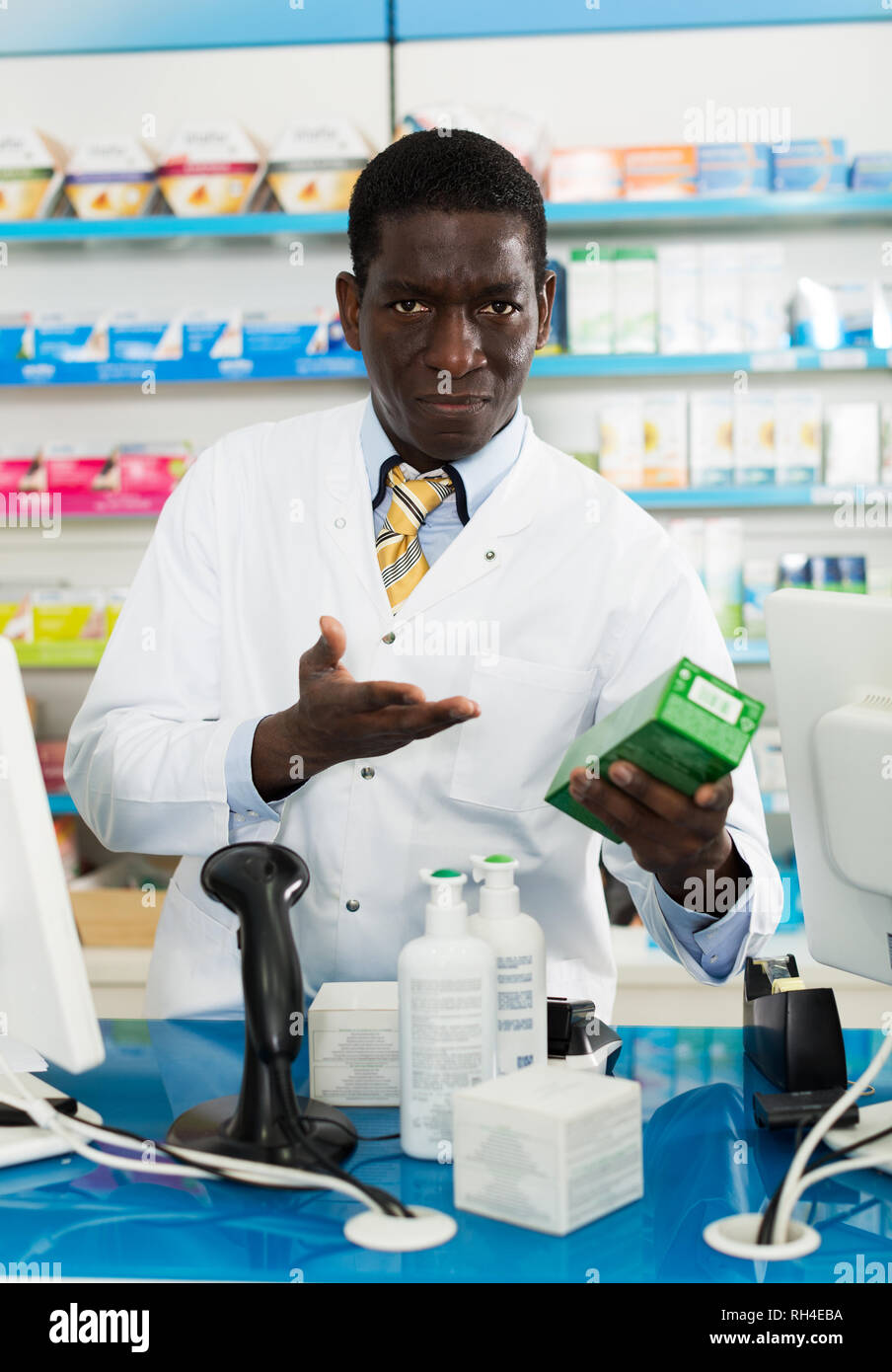 Positive adult African American pharmacist offering medication in ...