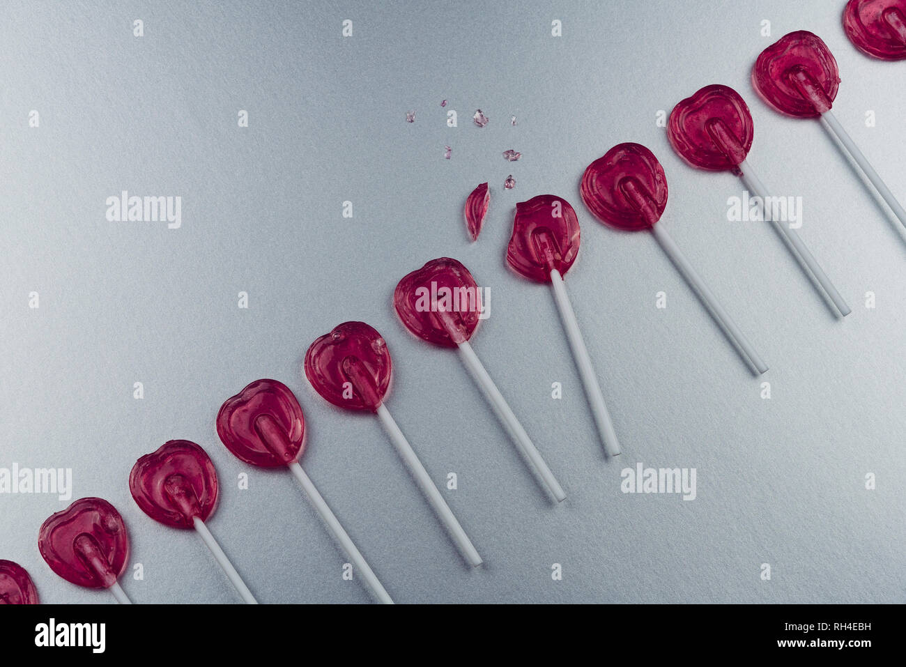Broken heart-shape lollipop in a row Stock Photo - Alamy