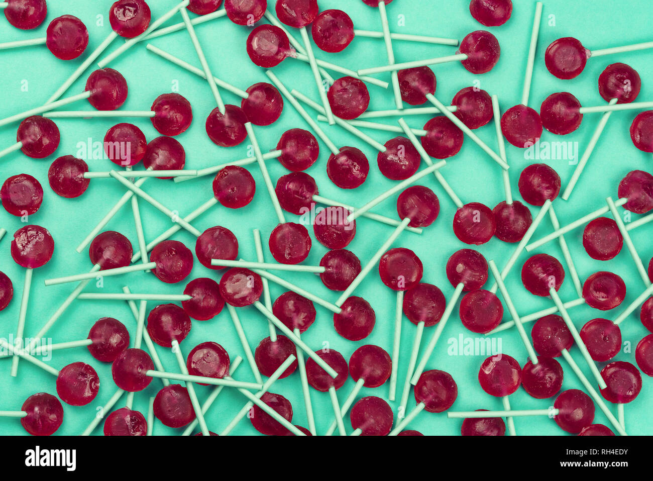 Red lollipops against green background Stock Photo - Alamy