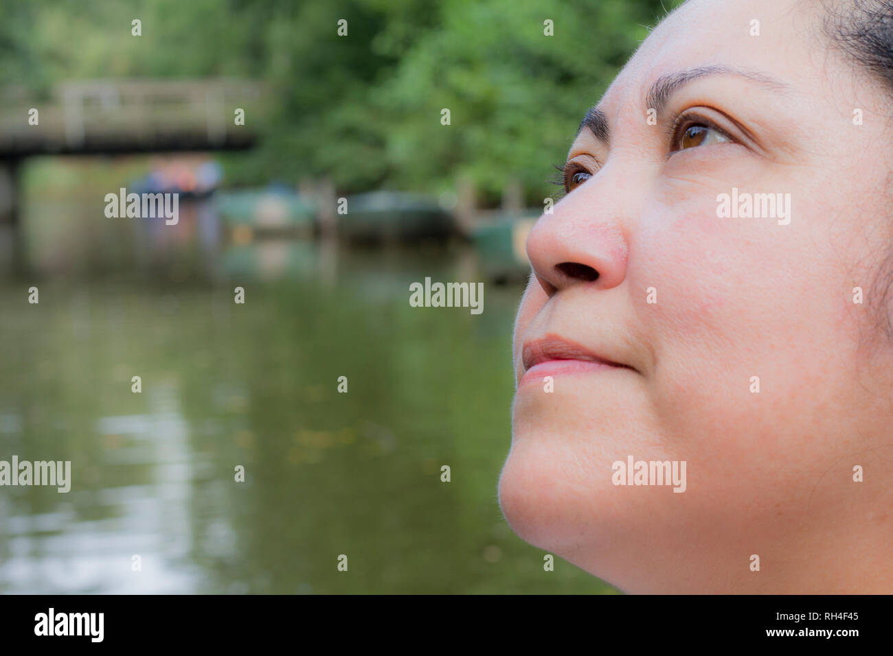 beautiful image of a thoughtful woman looking up to the sky with an ...